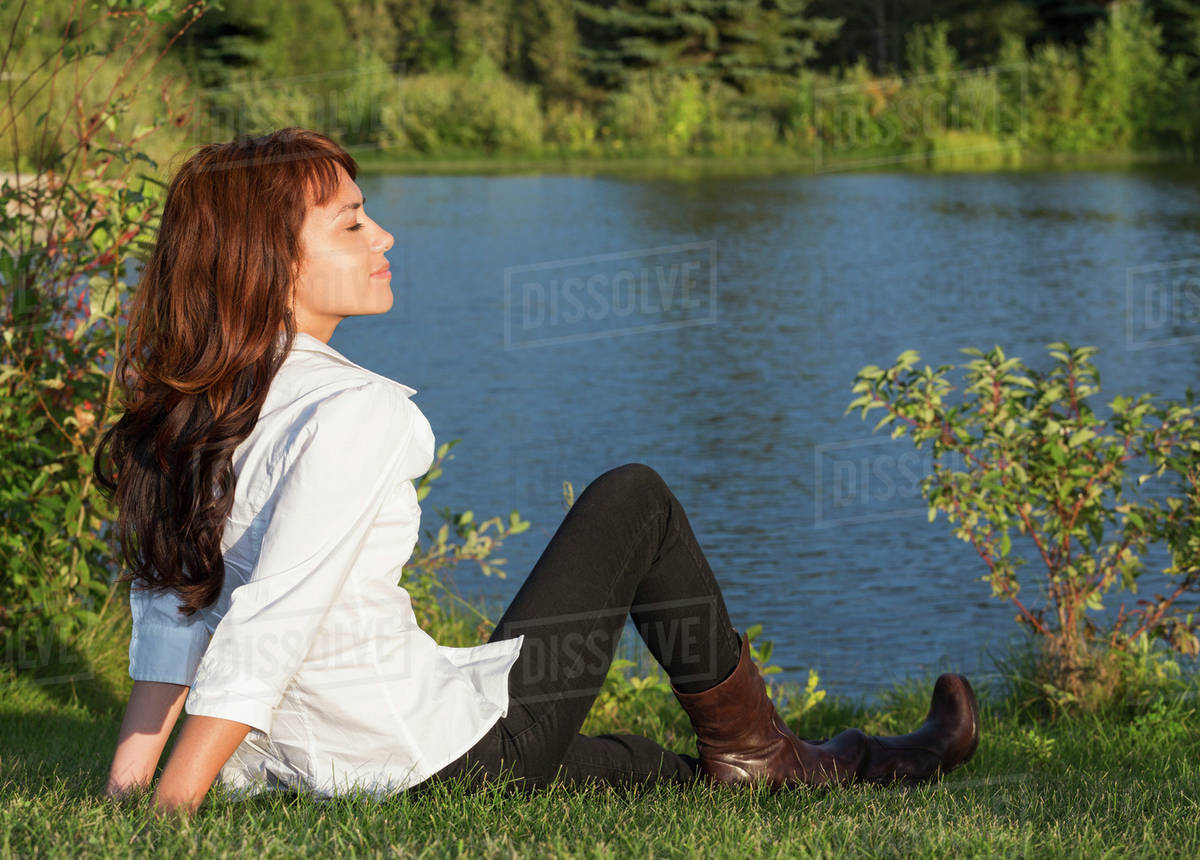 Young woman taking time for herself alone in a park; Edmonton, Alberta ...