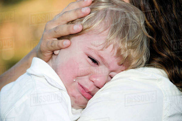 A young boy crying on his mother's shoulder; Edmonton, Alberta, Canada ...