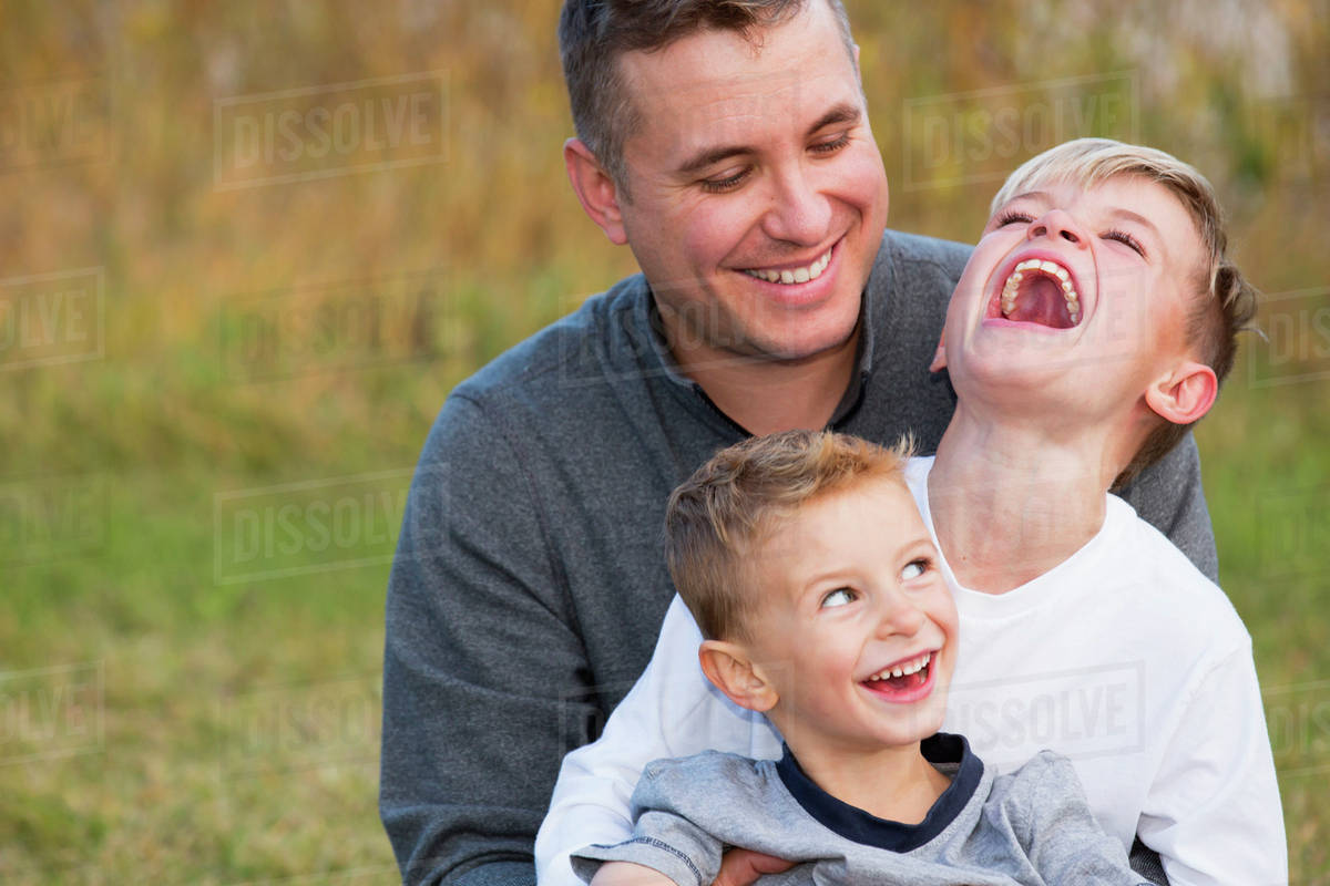 A father playing with his two sons in a park in autumn; Edmonton ...