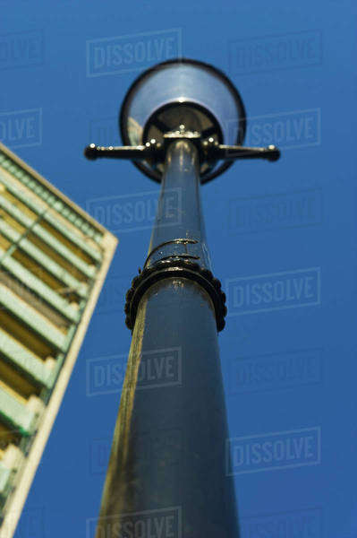 Low angle view of a lamp post, building and blue sky; London, England ...
