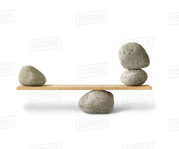 Rocks balancing on a seesaw - Stock Photo - Dissolve