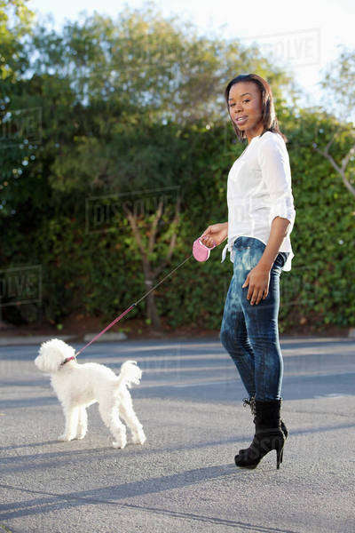 A woman walking her white dog; San Francisco, California, United States ...