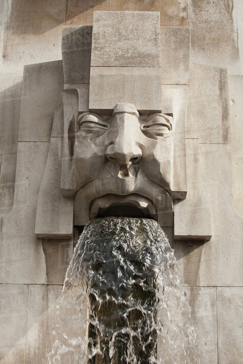 Close up of a face fountain on a stone building;Milano lombardia italy ...