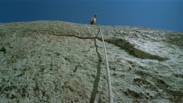 Man pulling out rock climber's rope. - Stock Video Footage - Dissolve