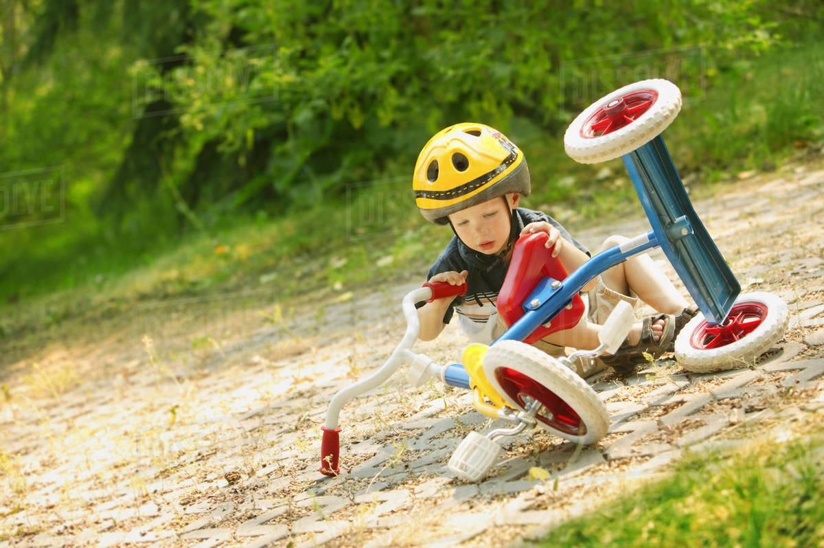Child Falling Off Tricycle - Stock Photo - Dissolve