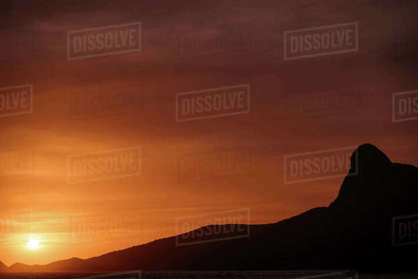 Golden sun glowing in a golden sunset sky; Bai Nhat, Con Dao, Vietnam ...