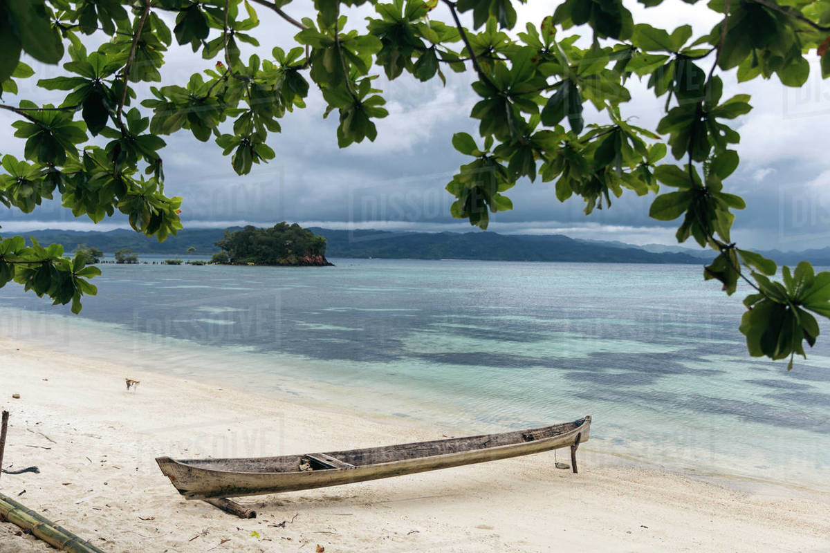 Traditional wooden canoe on the white sand of Taman Pantai, Indonesia ...