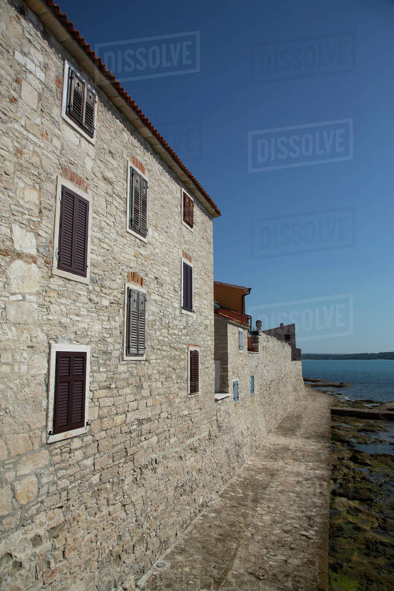 Outer city wall with residences along the seaside in the old town of ...