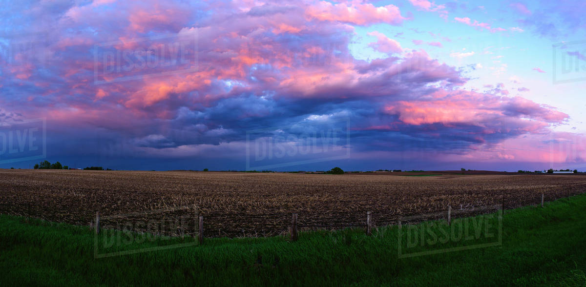 Agriculture - Brilliant clearing clouds pass over a farm field after a ...