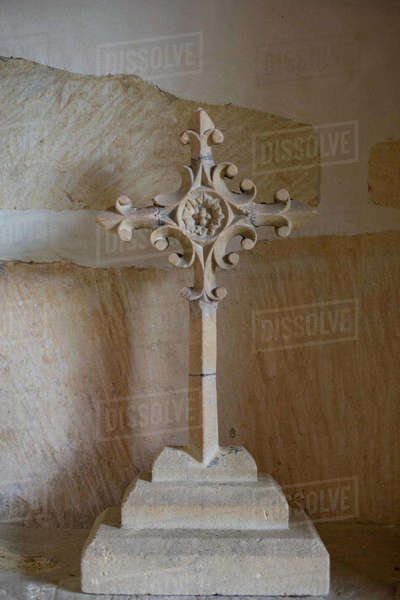 Close-up of decorative metal cross on stone base; Ampney Crucis ...