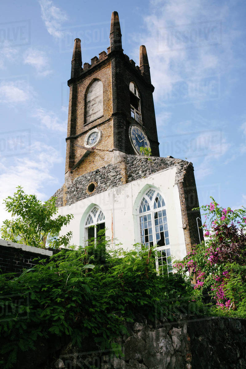 Close-up view of the clock tower and stone wall with windows against a ...