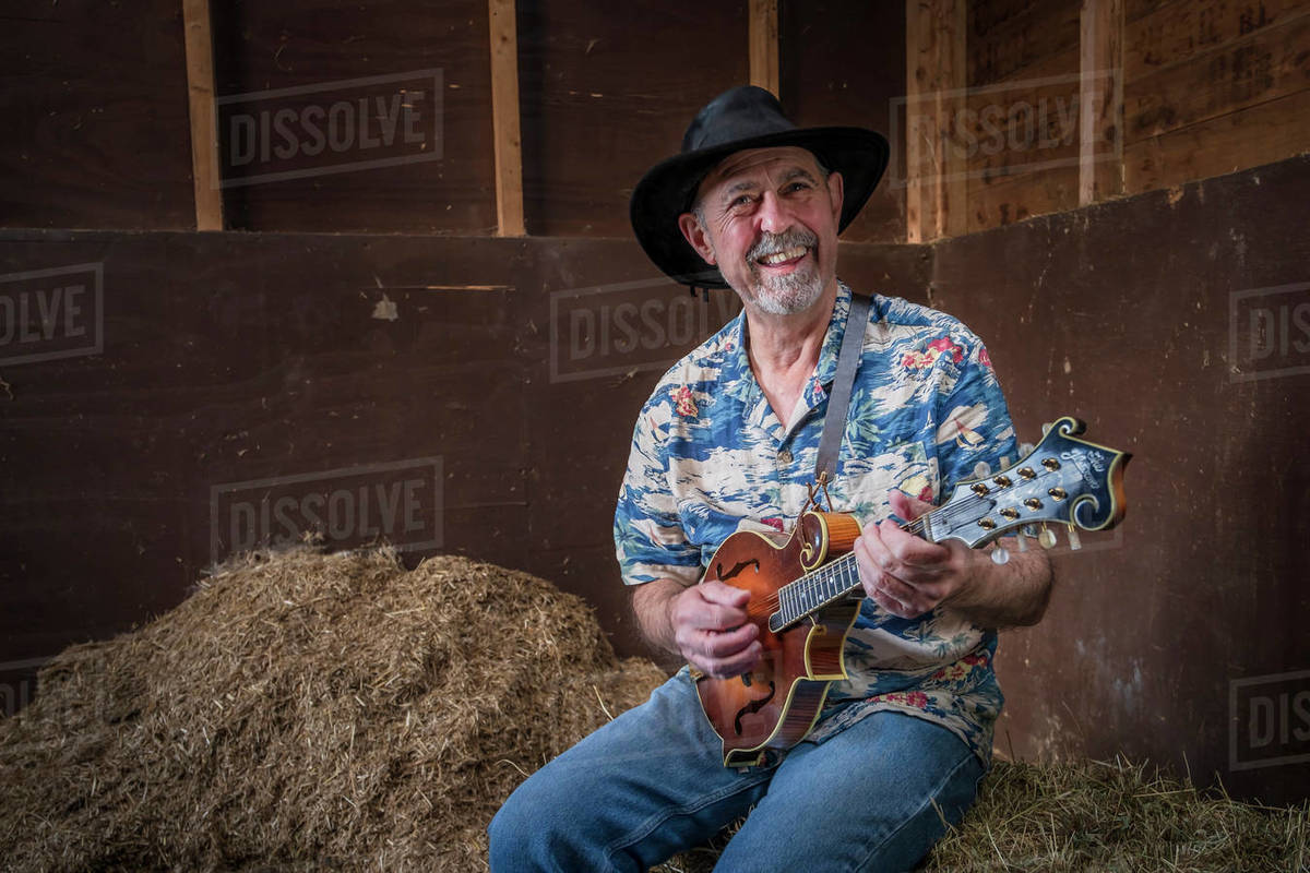 A happy man playing a mandolin in a stable. - Royalty-free Stock Photo ...