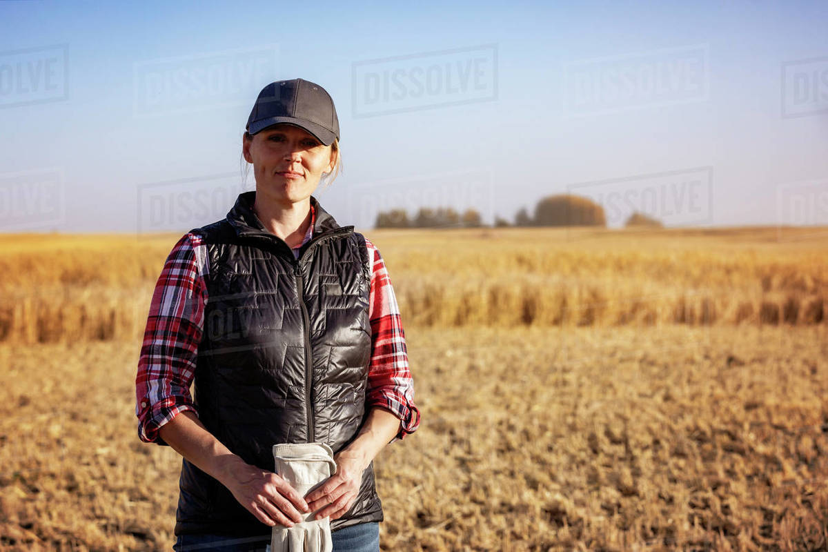 Portrait of a mature farm woman standing in a grain field, posing for ...