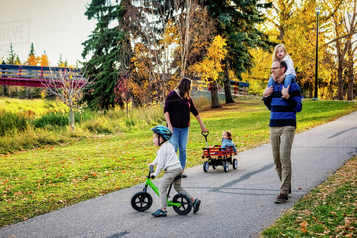 A mother pulling her daughter with Down Syndrome in a wagon, the father ...