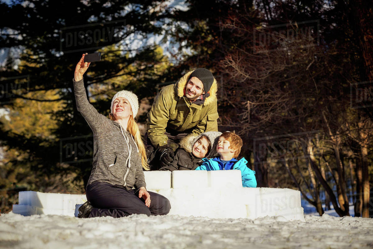 A Mother Takes A Self-Portrait Of Their Family Building An Igloo ...