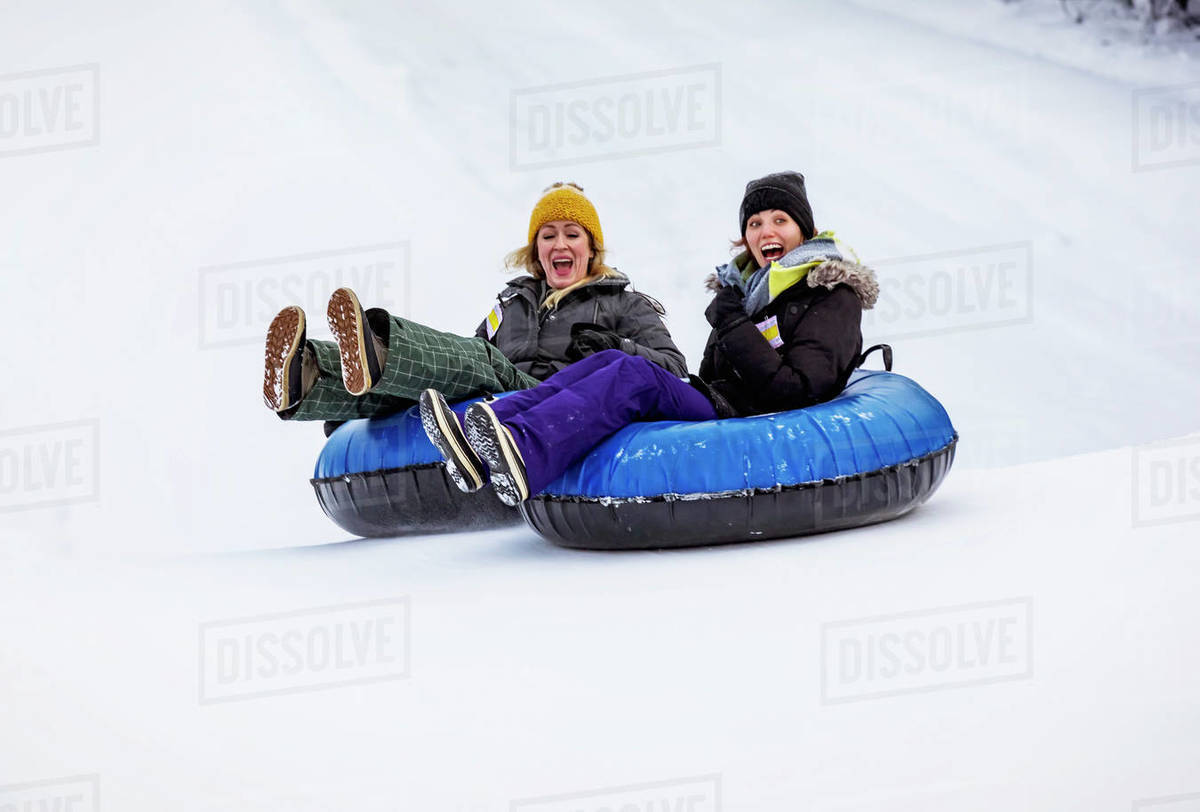 Two women tubing in tandem down a ski hill; Fairmont Hot Springs ...