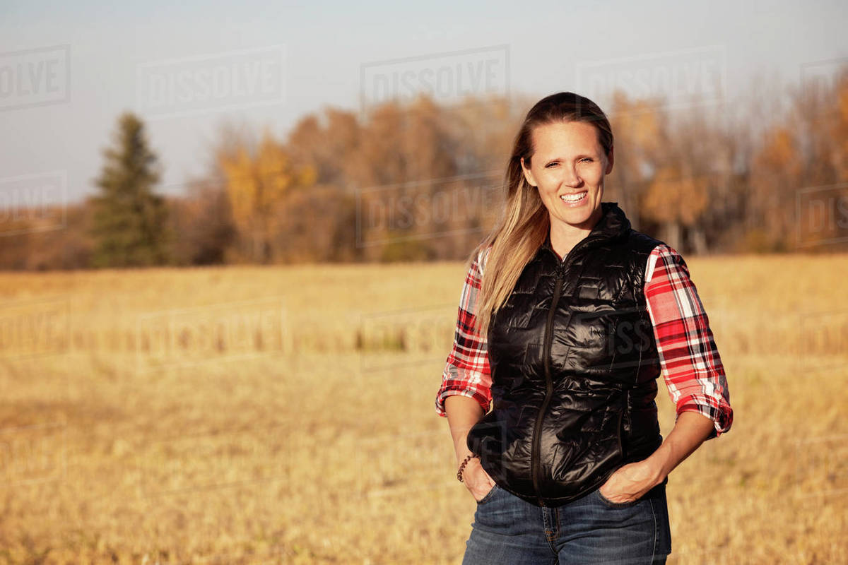 A portrait of an attractive farm woman, posing for the camera in a ...
