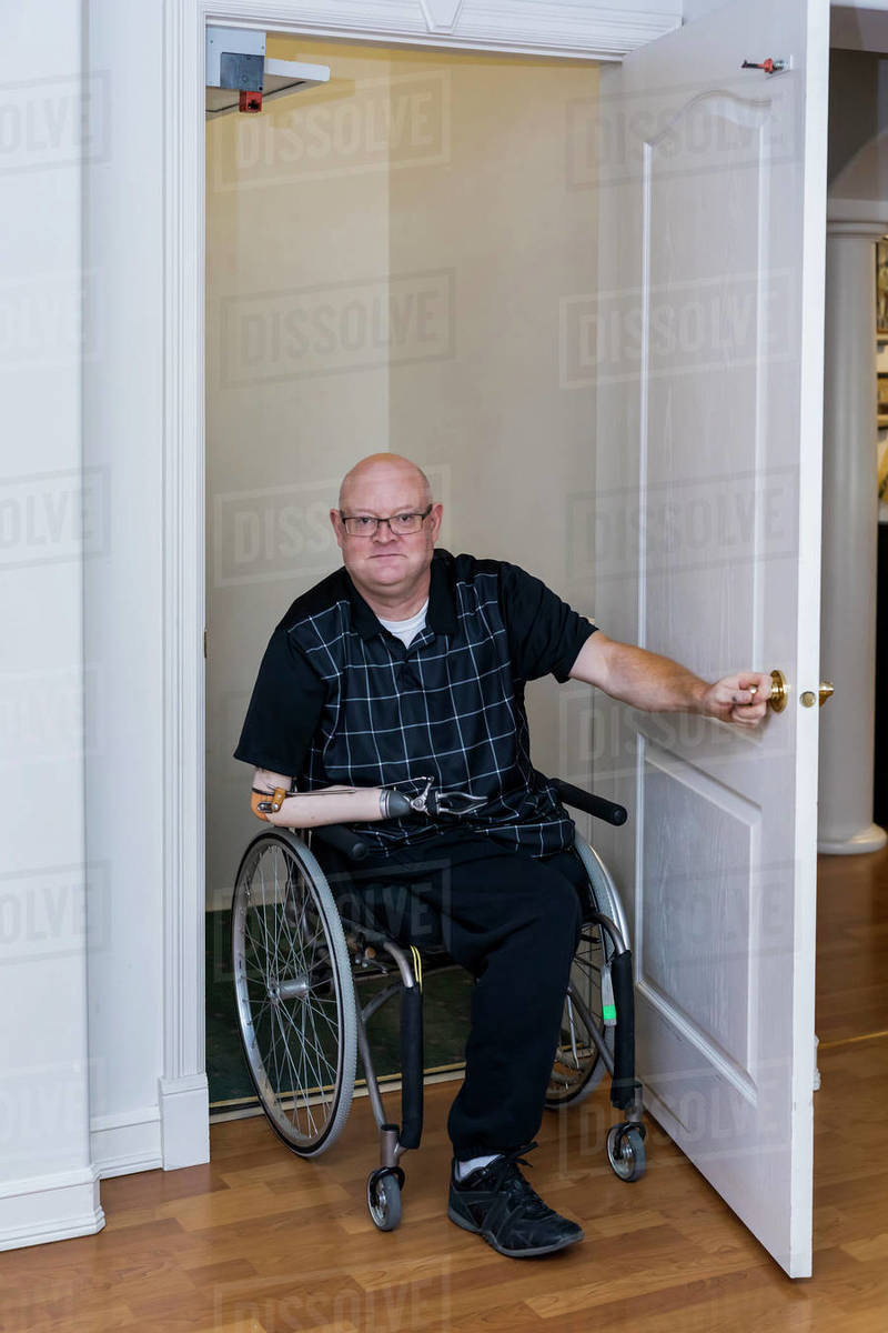 Man with double limb amputations entering home elevator; St. Albert, Alberta, Canada - Royalty ...