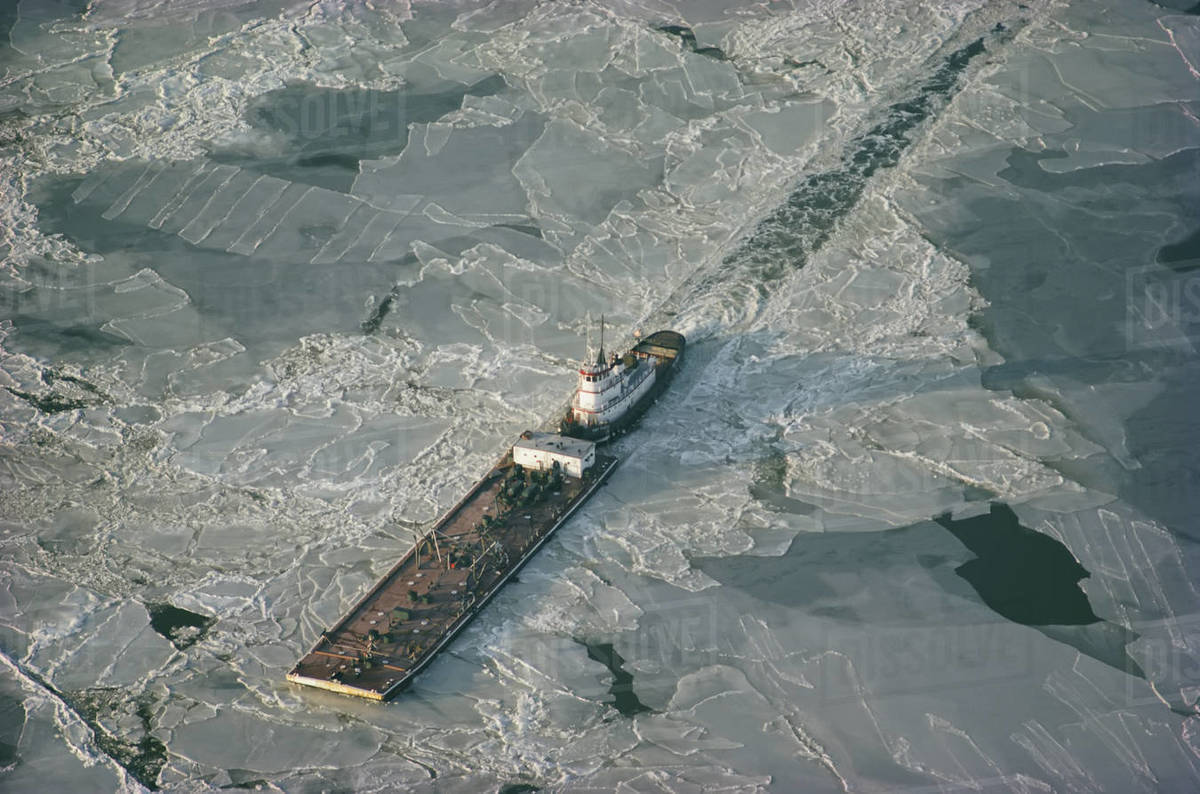 Tugboat pushing barge through winter ice on the Chesapeake Bay ...