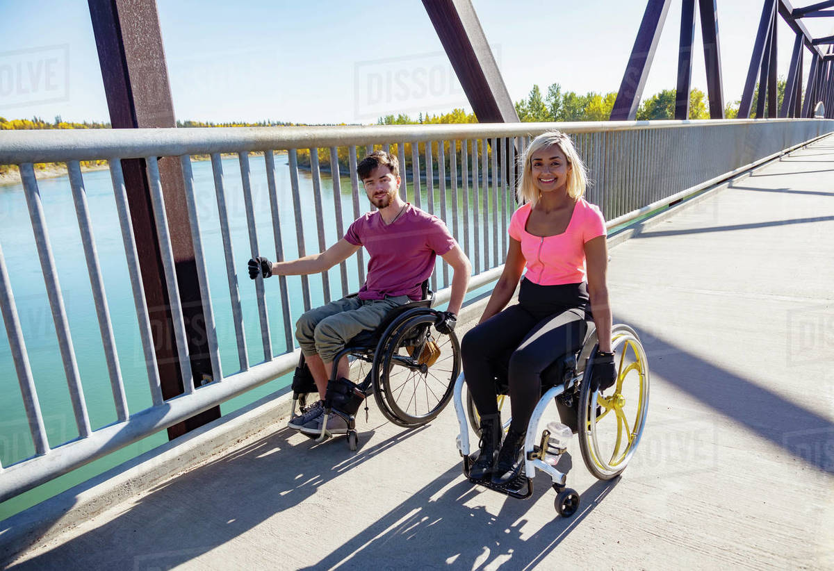 Two young paraplegic friends spending time together moving across a ...