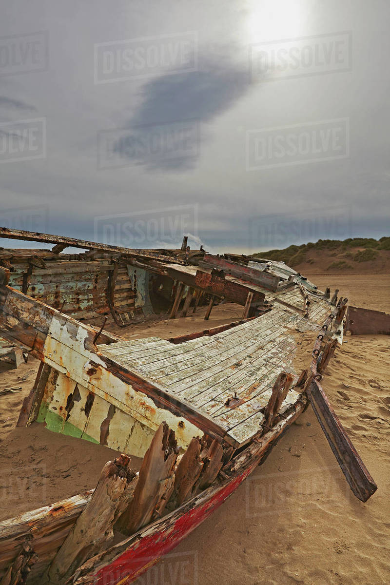 Weathered shipwreck lying in sand dunes at Crow Point, at the mouth of ...