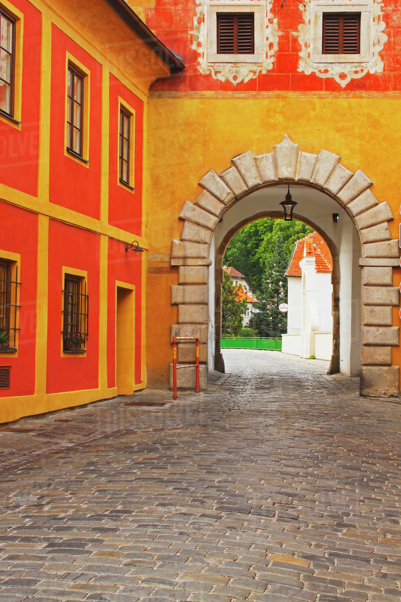Arch And Cobblestone With An Orange And Yellow Building In Old Town ...