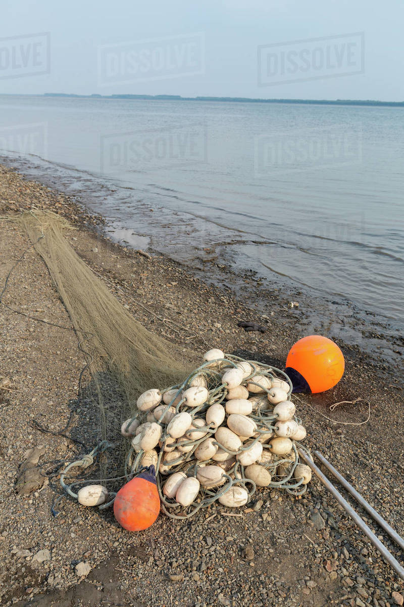 Commercial fishing nets with floats and buoys on the beach along the ...