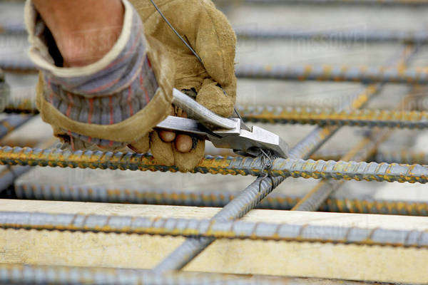 Workers Gloved Hands Tying Rebar With Pliers And Metal Wire; Canada ...