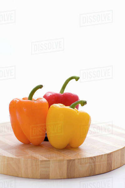 Yellow, Orange And Red Peppers On Butcher Block Cutting Board - Royalty ...