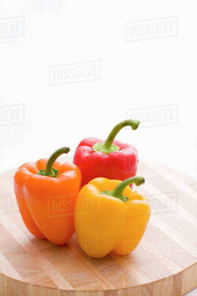 Yellow, Orange And Red Peppers On Butcher Block Cutting Board - Stock ...