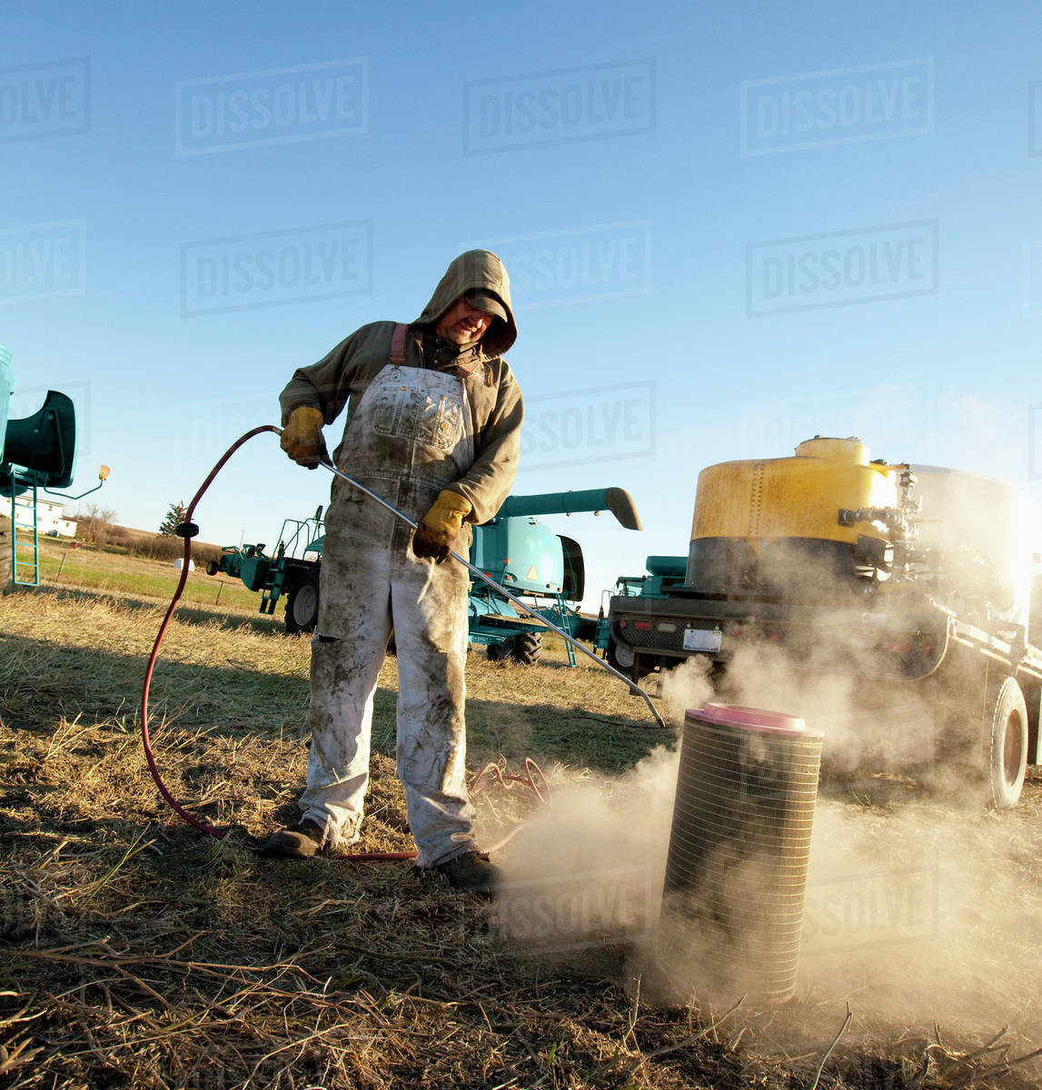 A Man Cleaning Farm Equipment; Three Hills, Alberta, Canada - Royalty ...