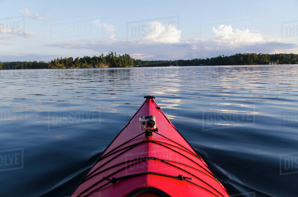 The bow of a red kayak in a lake;Lake of the woods ontario canada ...