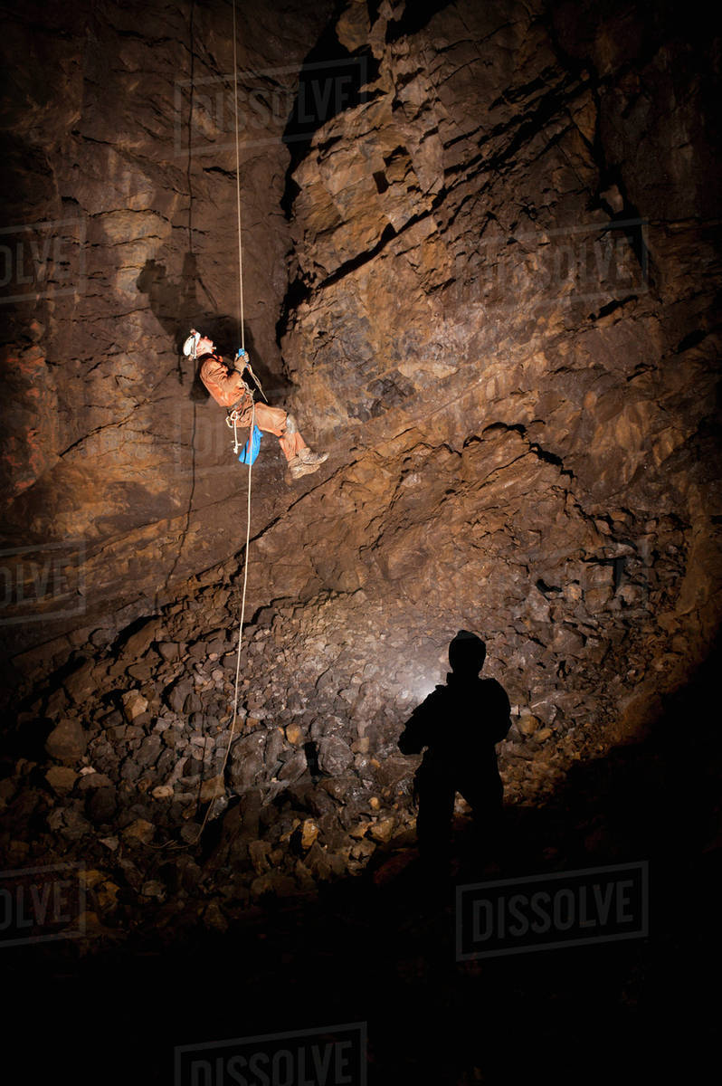 Male Athlete Ascending A Rope To Exit A Cave; Fernie, British Columbia ...