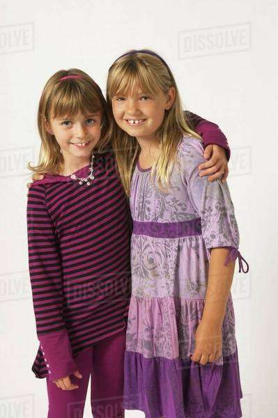 Two Girls Wearing Purple With Their Arms Around Each Other - Royalty ...