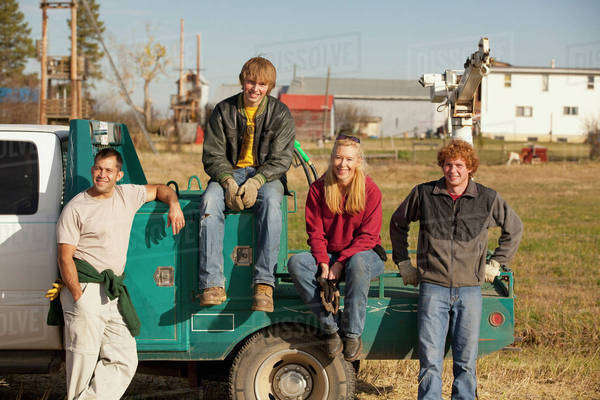 A Group Of People Sitting On The Back Of A Truck; Three Hills, Alberta ...