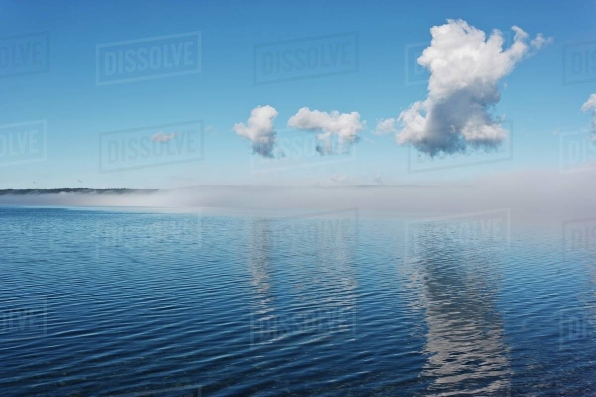 Fog Clearing From Surface Of Lake To Reveal Blue Water Under Blue Sky ...