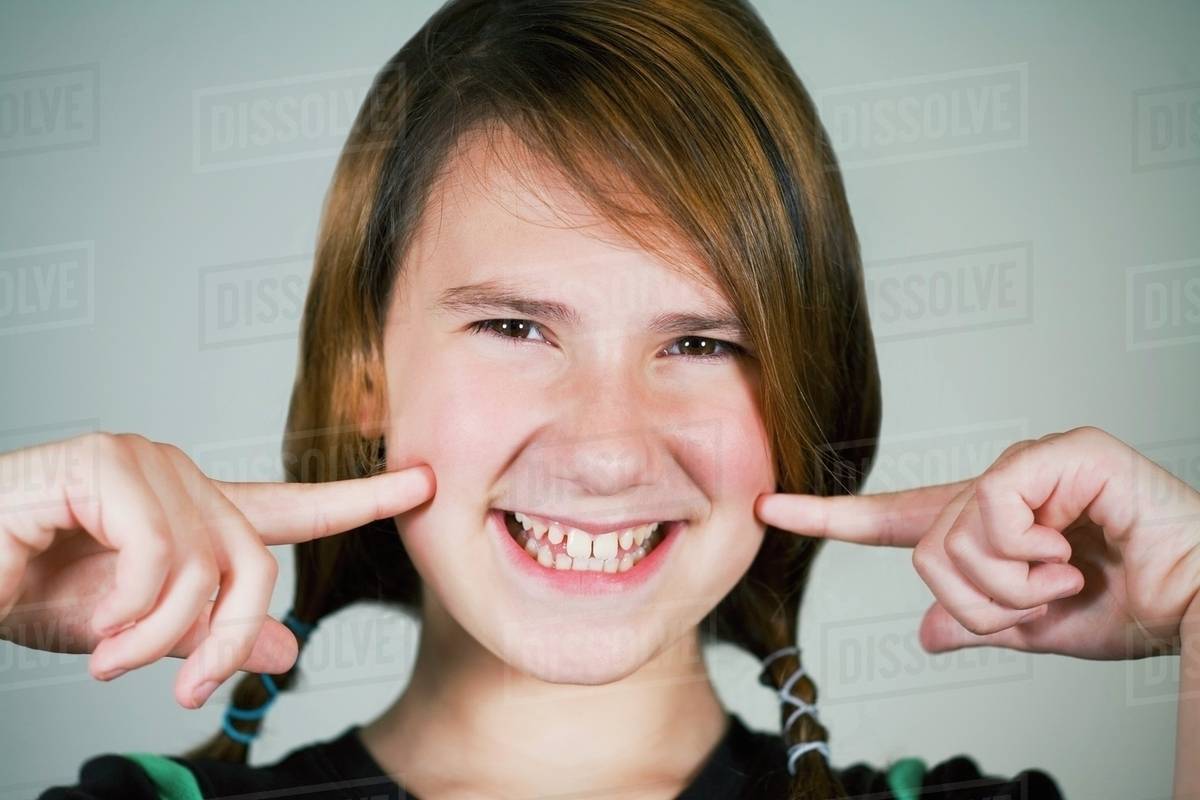 Portrait Of A Girl Pointing To Her Cheeks And Smiling - Royalty-free ...