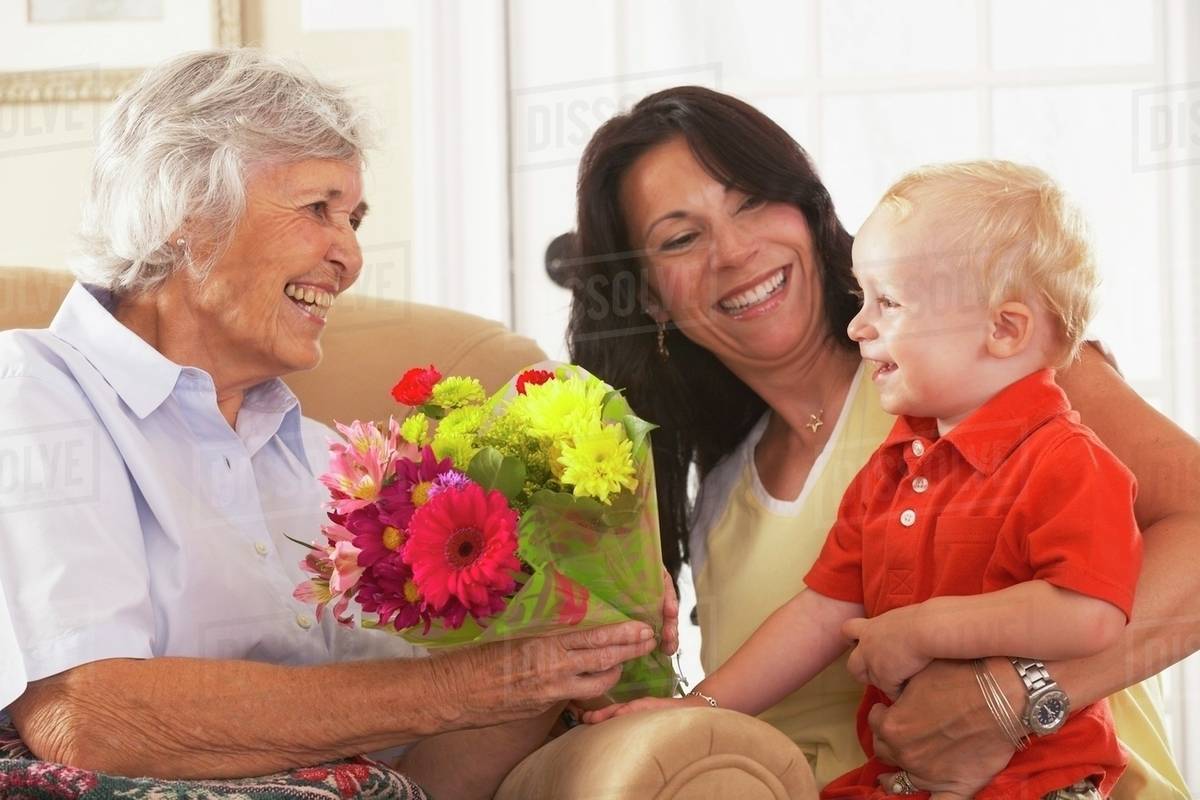 A Young Child Giving Flowers To His Grandmother - Royalty-free Stock ...