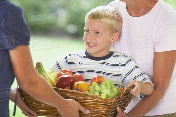 A Boy Giving A Basket Of Fruit - Stock Photo - Dissolve