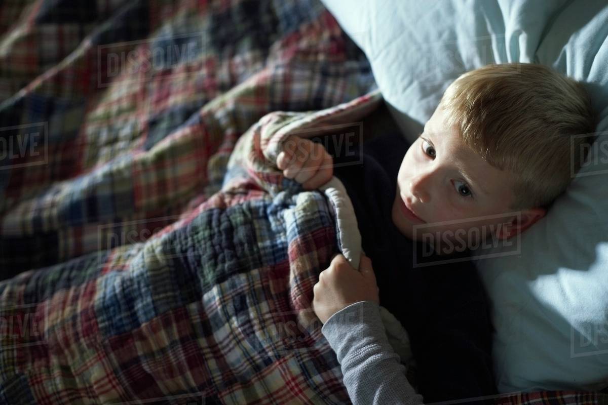 A Boy Laying Awake In Bed - Stock Photo - Dissolve