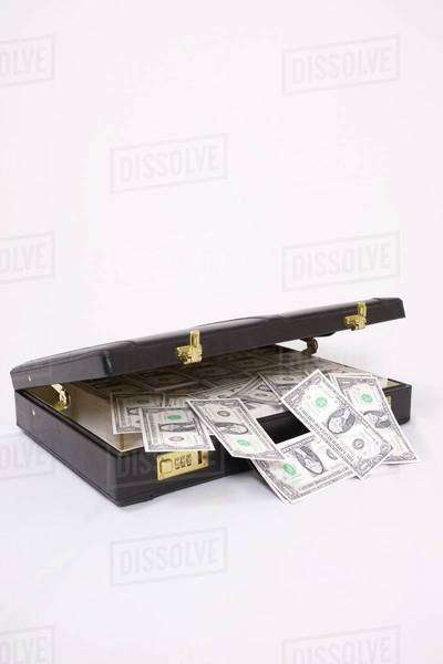 Briefcase With Money Spilling Out - Royalty-free Stock Photo | Dissolve