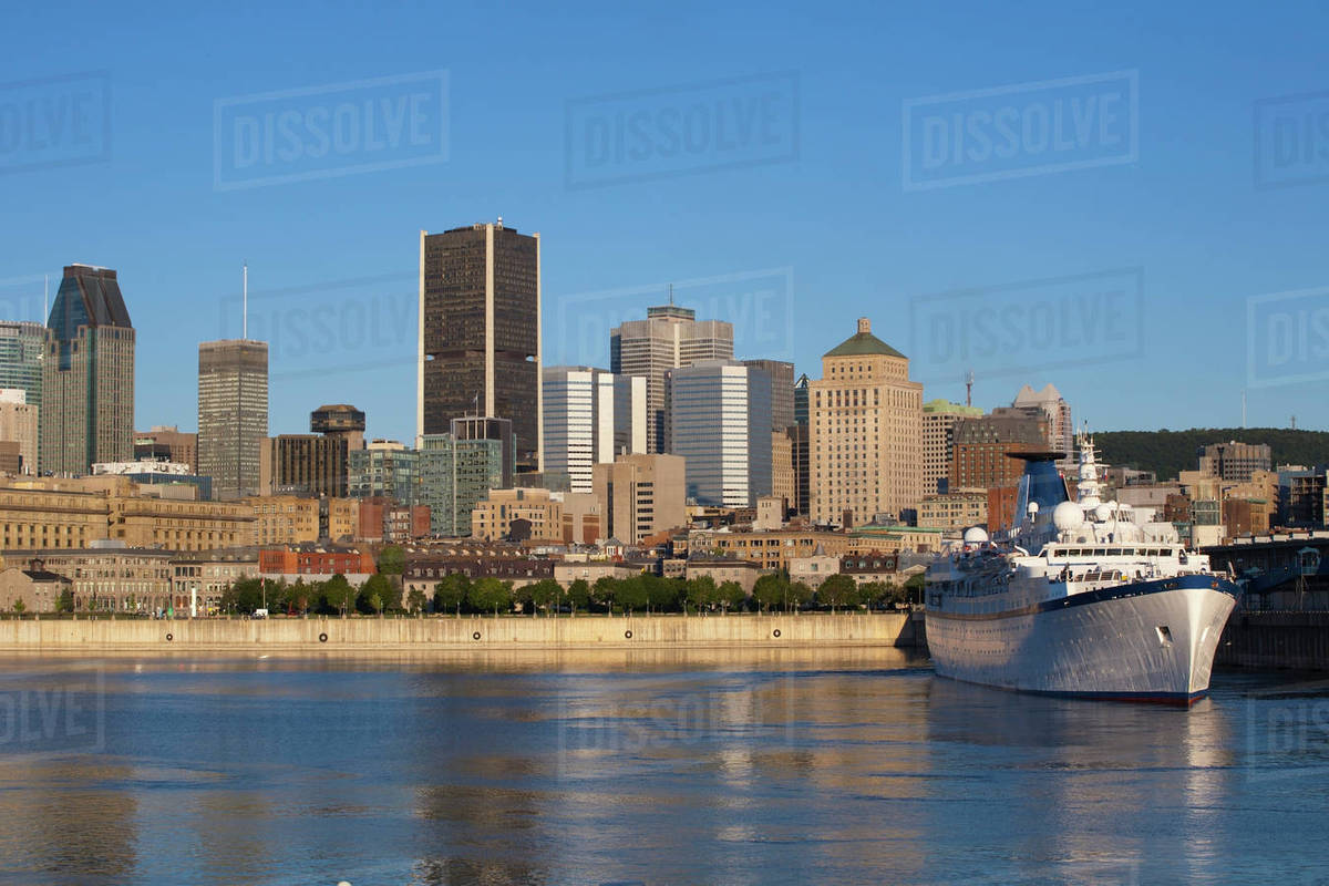 An Ocean Liner In The Water With The Montreal Skyline; Montreal, Quebec ...