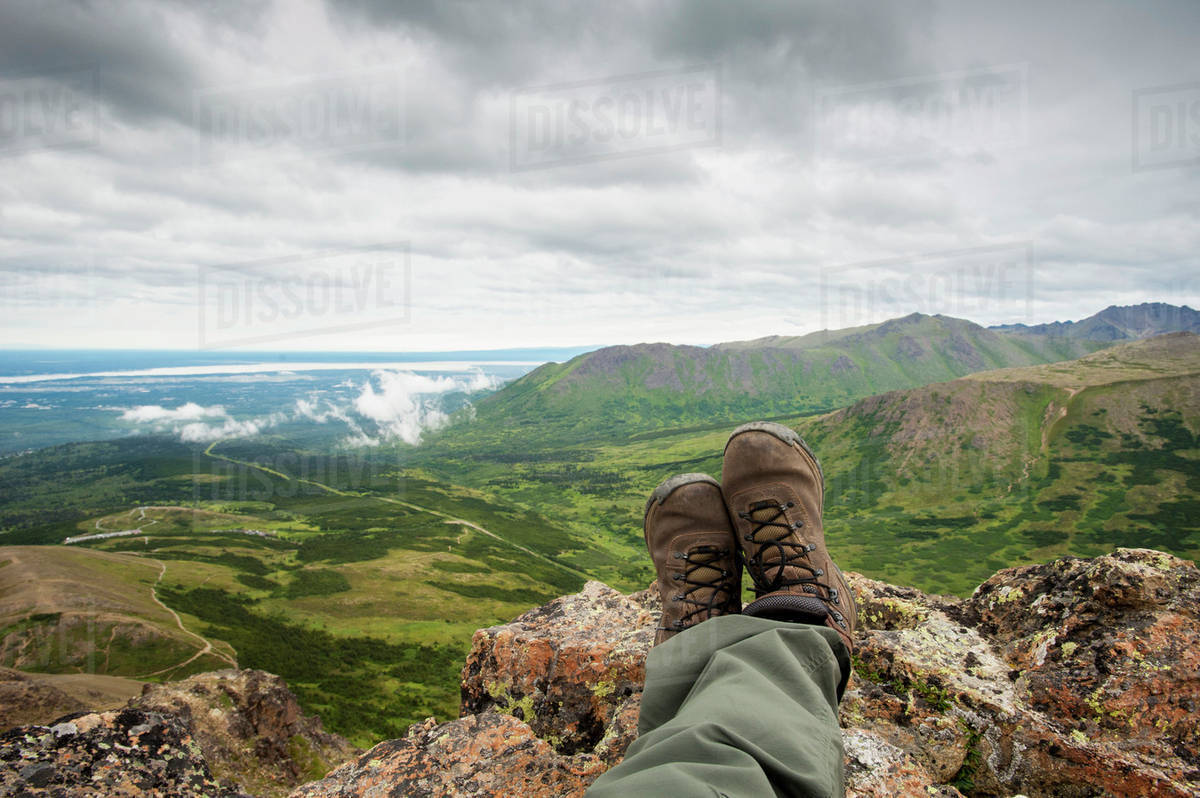 POV of hikers legs and feet as he rests and enjoys the view from Flat ...