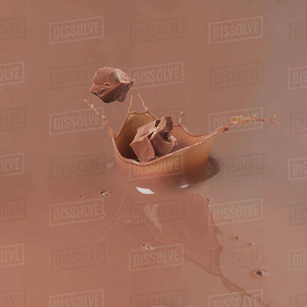 Pieces of chocolate splashing into melted chocolate - Royalty-free ...