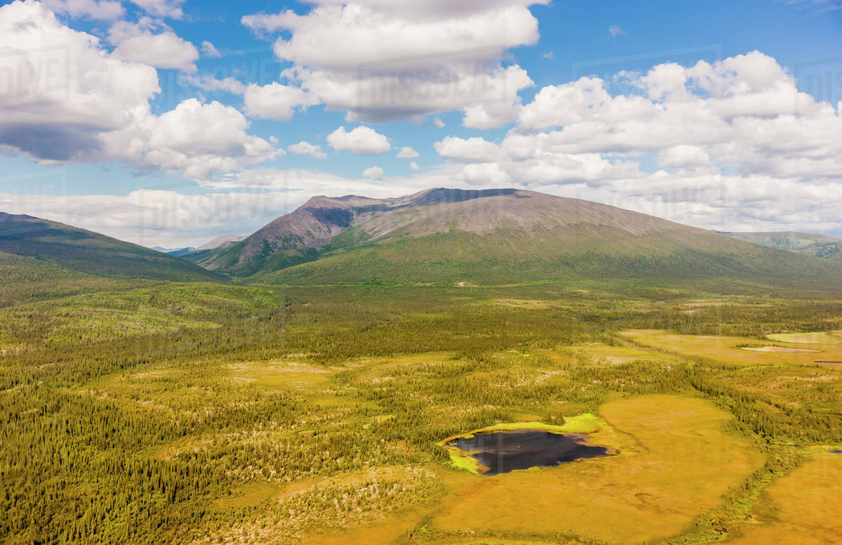 Aerial view of the Baird Mountains, green tundra and a small lake ...