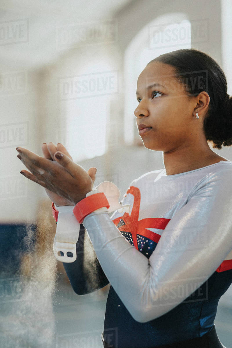 Female gymnast applying chalk powder on hands at gym - Royalty-free ...