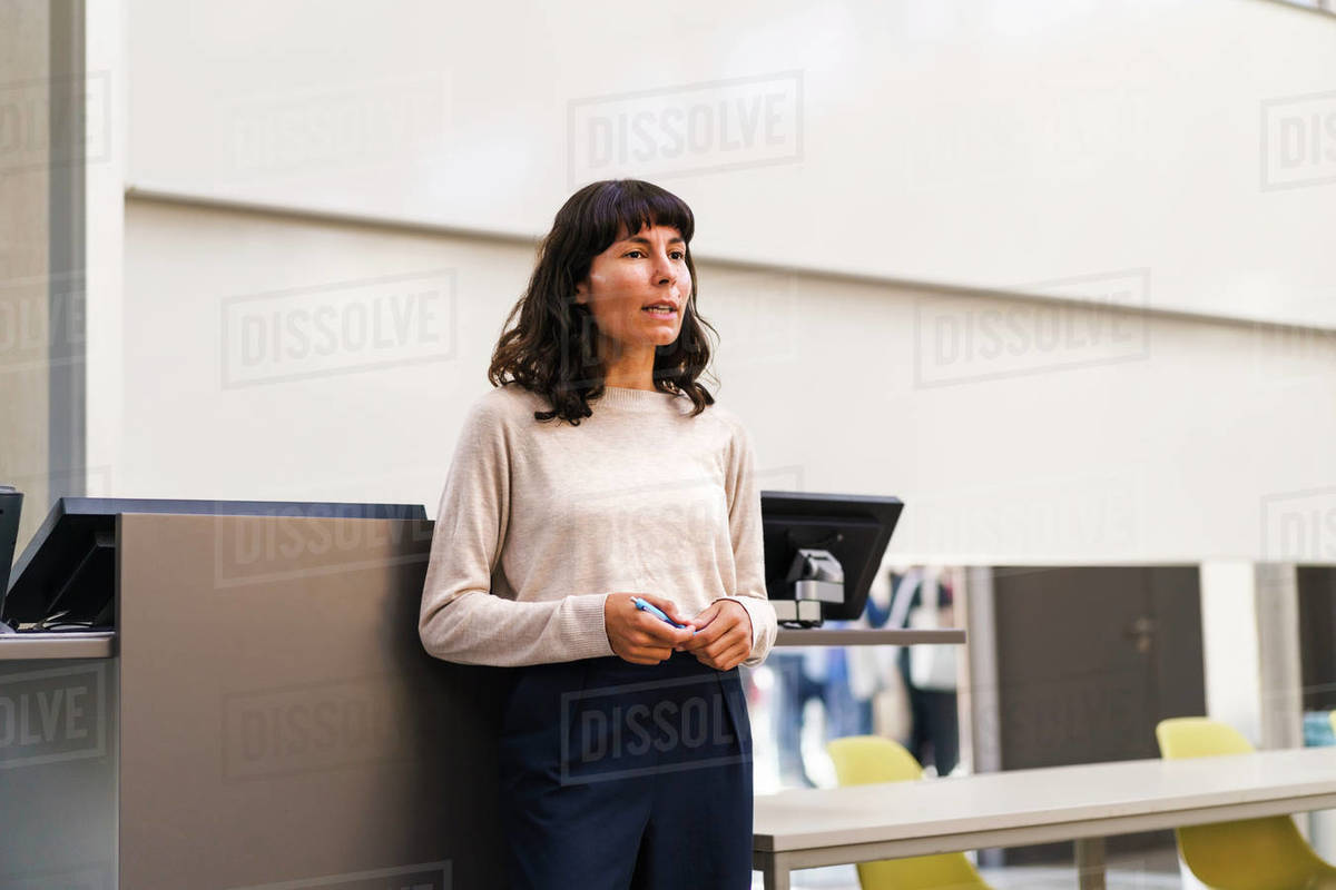 Confident female teacher explaining while standing in lecture hall at ...