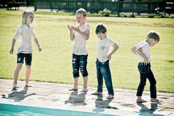 Full length of four children standing by swimming pool - Stock Photo ...