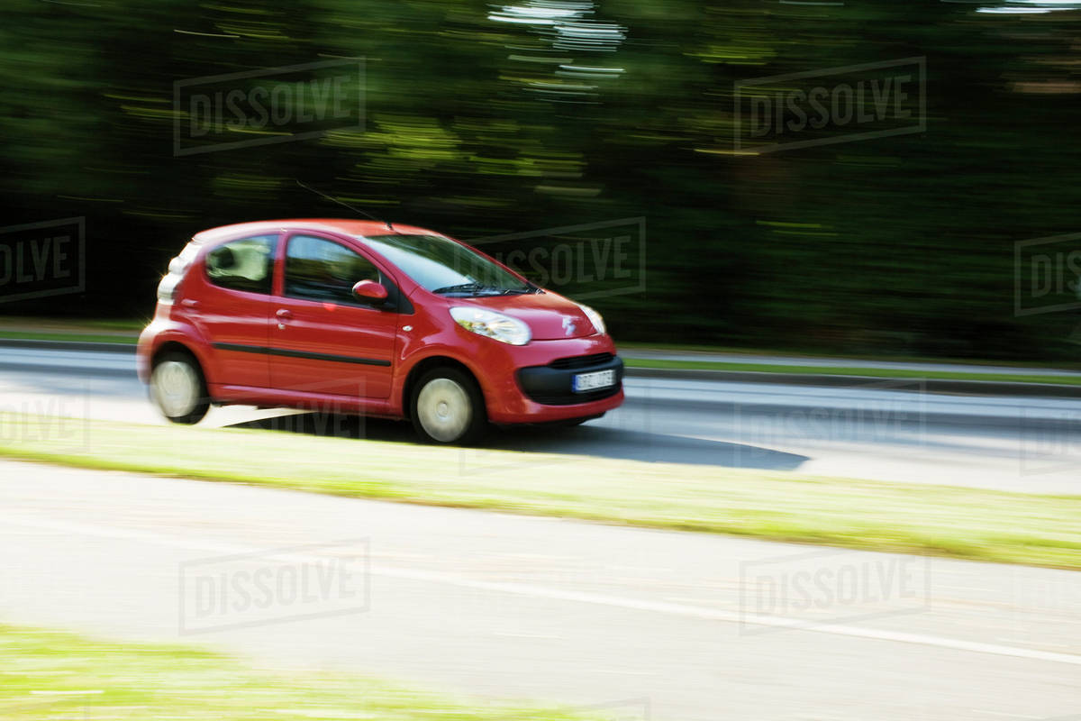 Red car moving fast on highway - Stock Photo - Dissolve