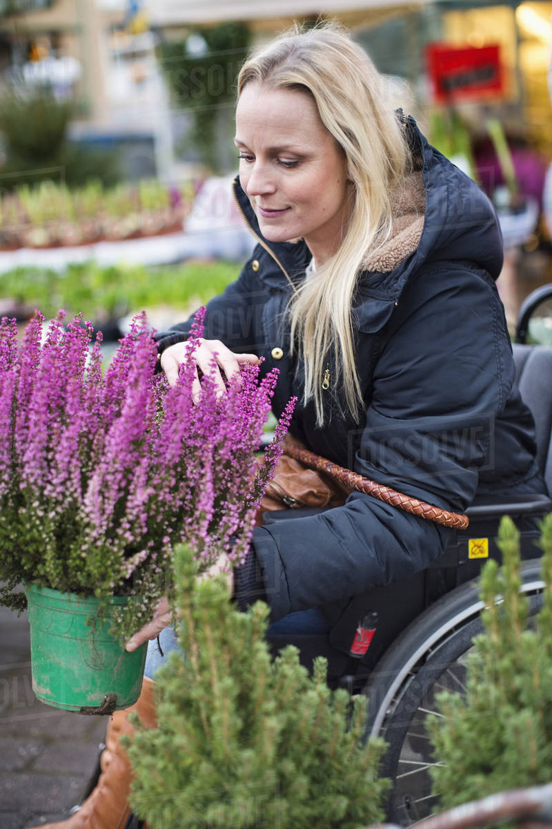 Disabled woman in wheelchair choosing plants at garden center - Stock ...